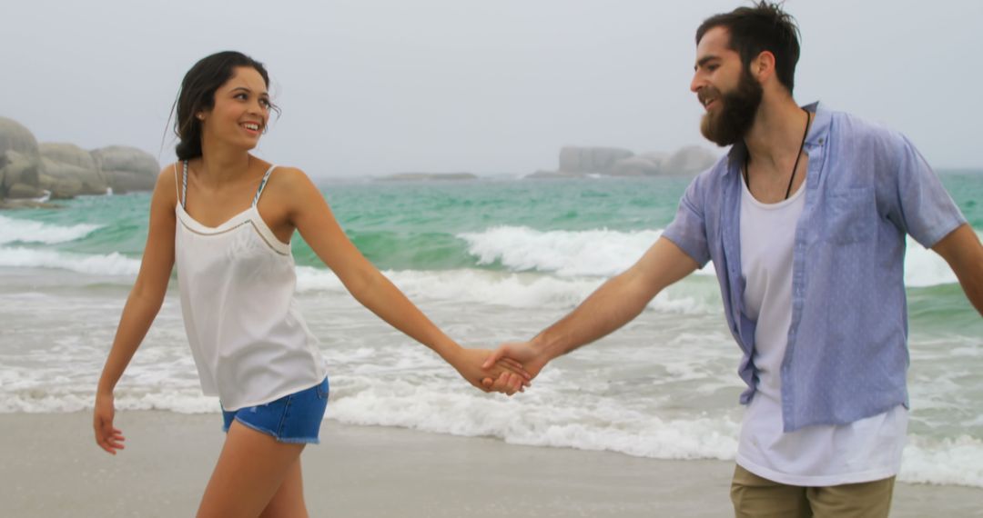 Romantic couple strolling hand in hand on sandy beach - Free Stock ...