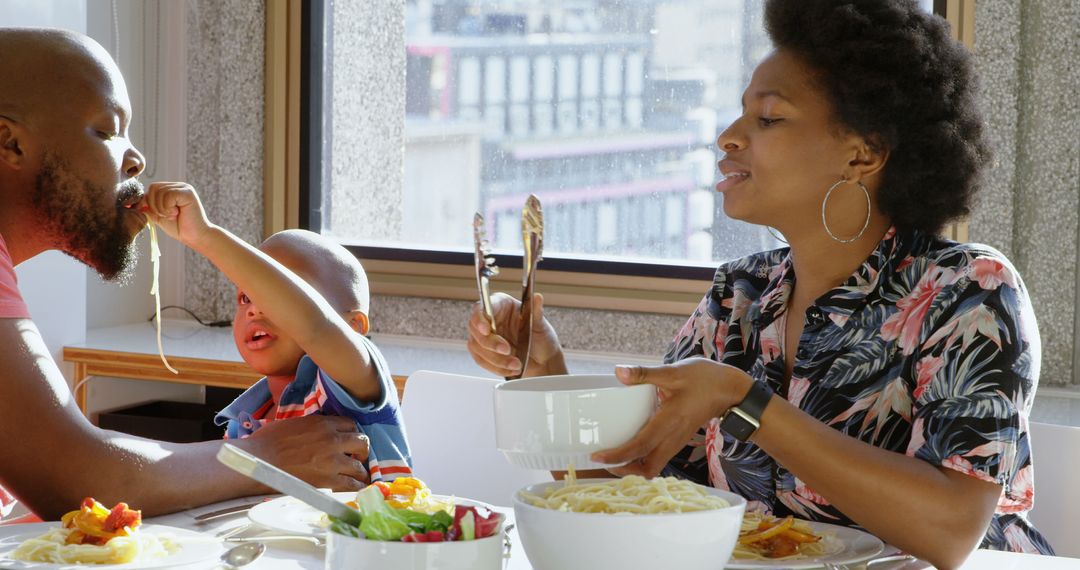 family dining together and sharing pasta meal joyfully - Free Stock ...
