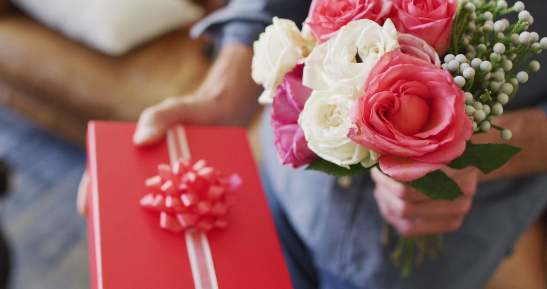 Man offering red gift box and pink rose bouquet close-up - Free Stock ...