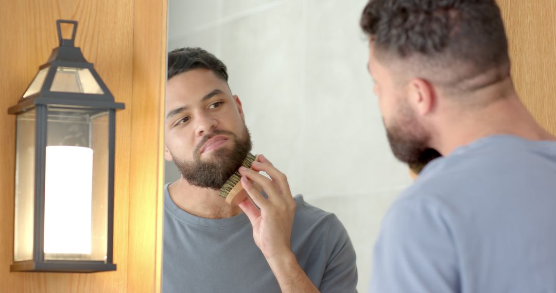 Man Grooming Beard with Wooden Brush in Bathroom Mirror Reflection ...