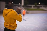 Coach Encouraging Runner During Night Training at Stadium - Download ...