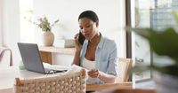 Young Woman Multitasking with Laptop and Smartphone at Home Office ...